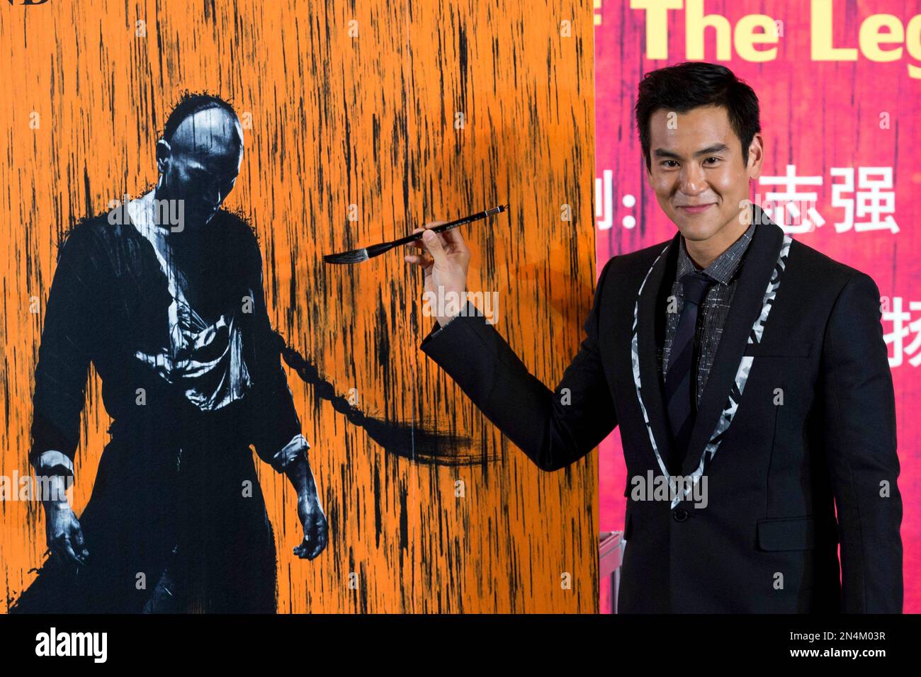 Taiwan actor Eddie Peng, poses with a ink brush as he unveils a movie ...