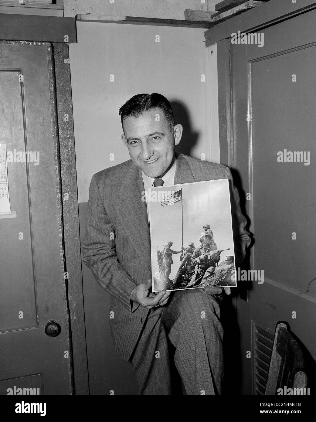 Lou Lowery, photographic director of Leatherneck Magazine, holds his ...