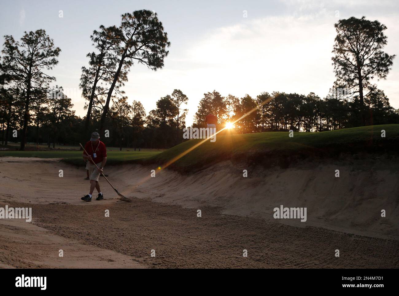 Ron Lewandowski, a grounds keepers works in a bunker on the 17th hole ...
