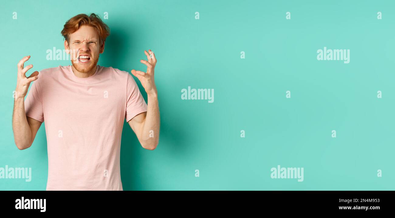 Annoyed and pissed-off redhead guy looking angry, shouting and ...