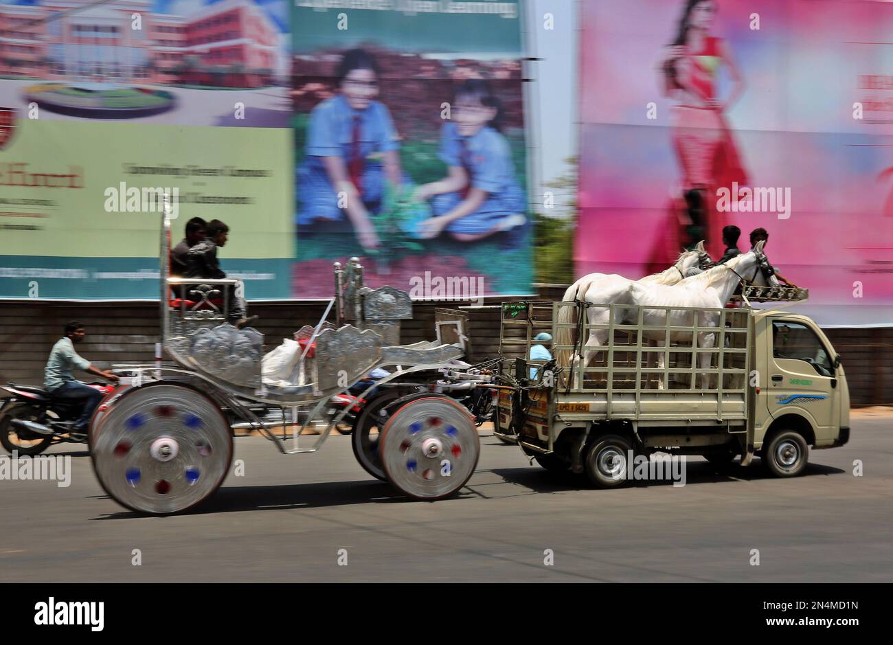 An Indian auto rickshaw trolley carries horses and its cart on a street ...