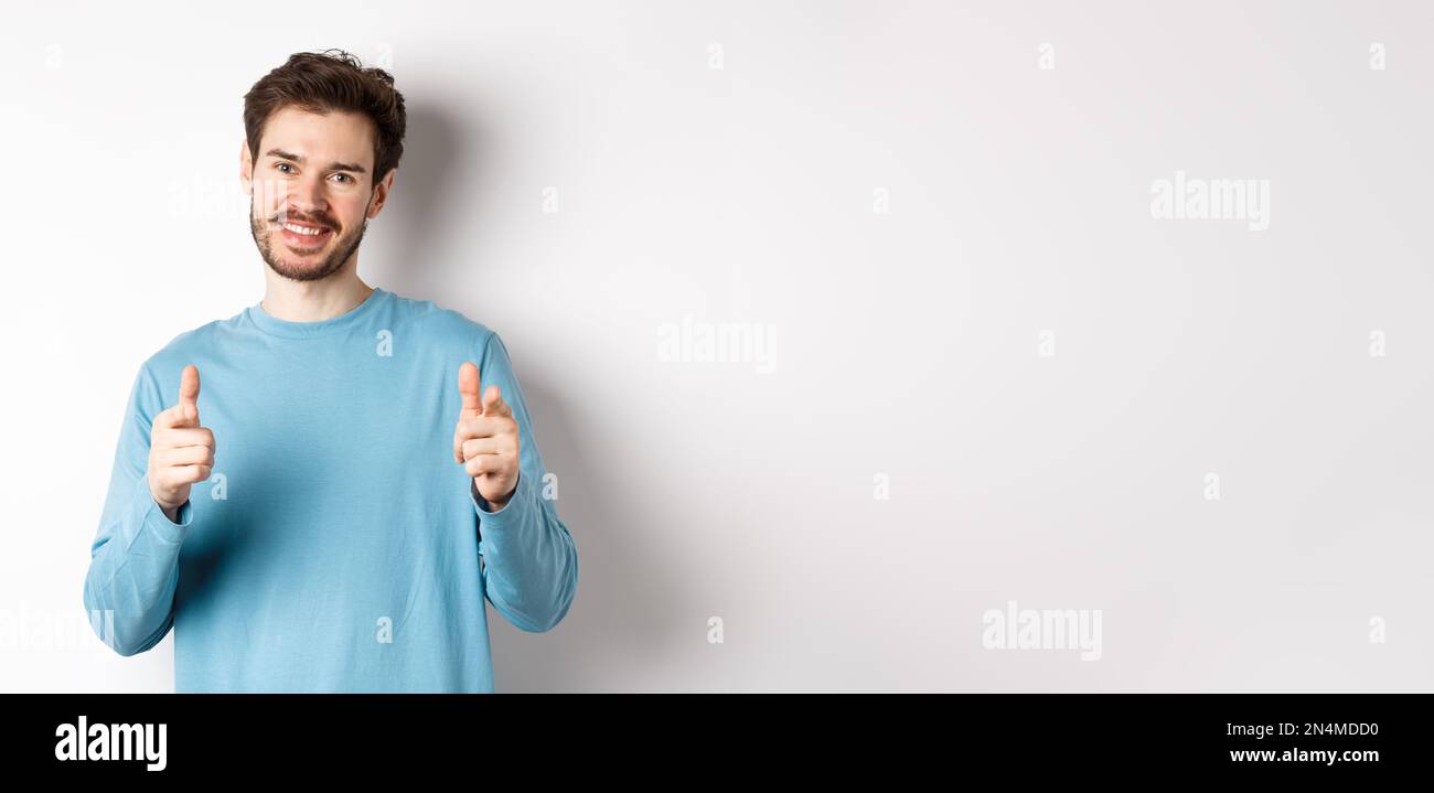 Well done. Smiling handsome man pointing fingers at camera to ...