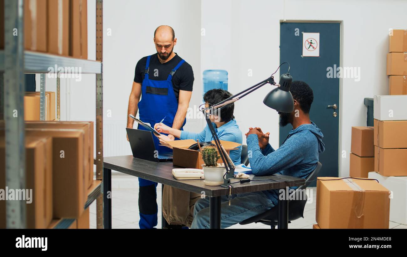 Team of entrepreneurs preparing merchandise order in storage room ...