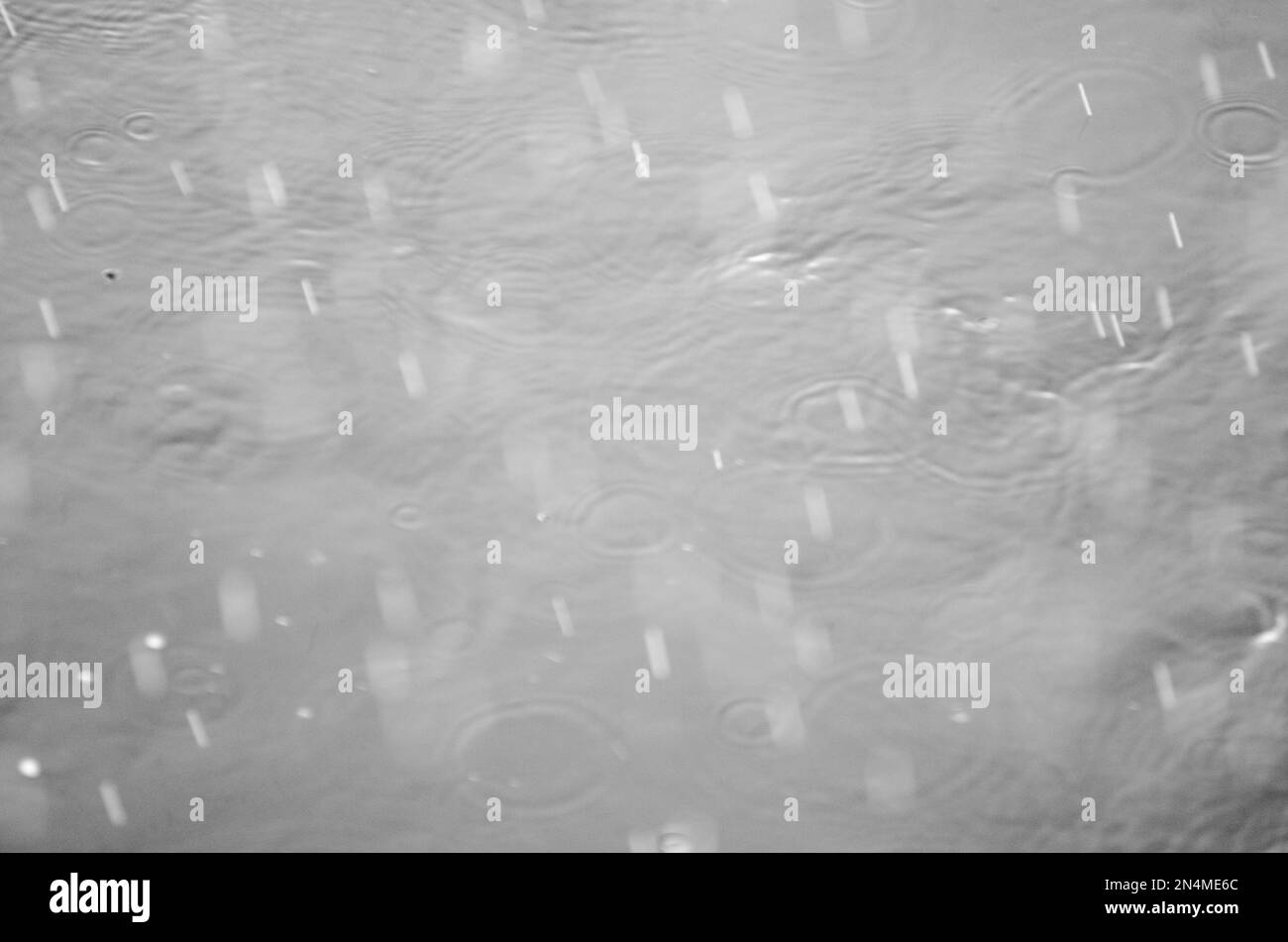 Many drops of hail and rain with fast speed break on the water surface ...