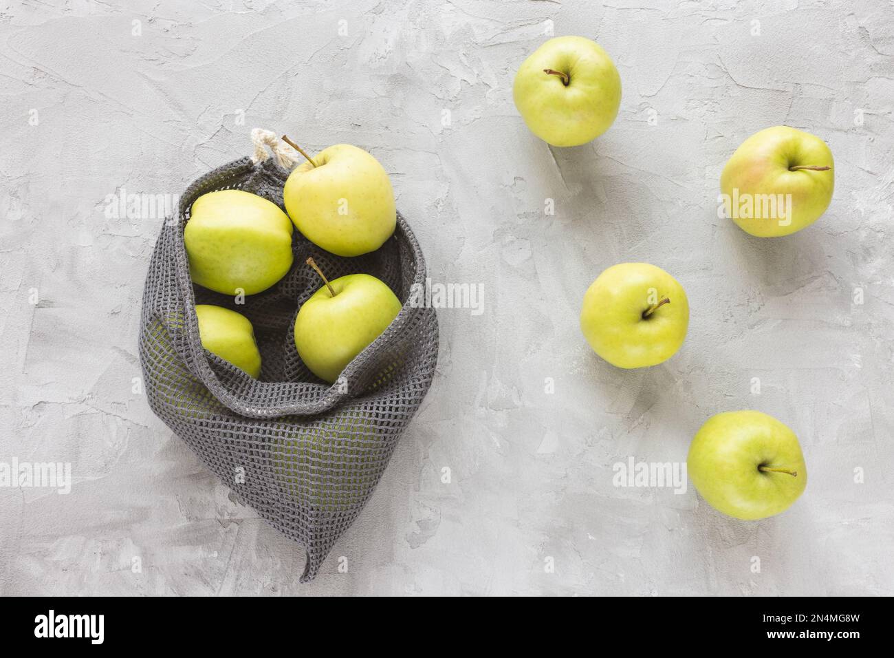Reusable shopping mesh bag on gray with apples background. Healthy ...