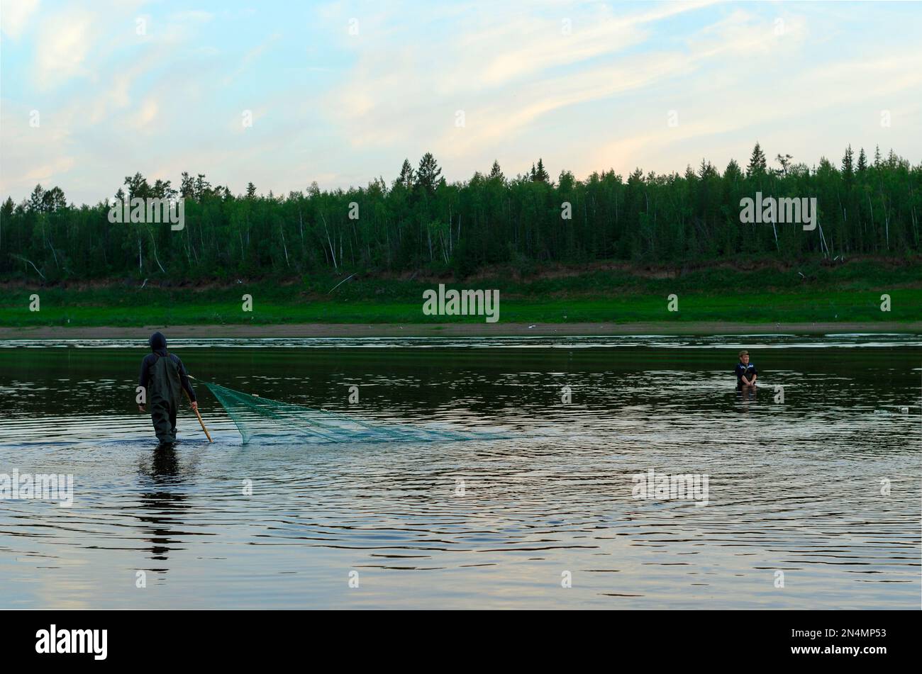 Two men Yakuts go in wading boots with fish net on the wildlife in the ...