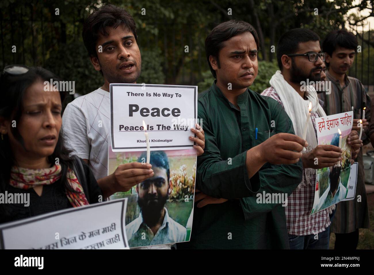 Civil society members hold candles and photographs of Indian Muslim man ...