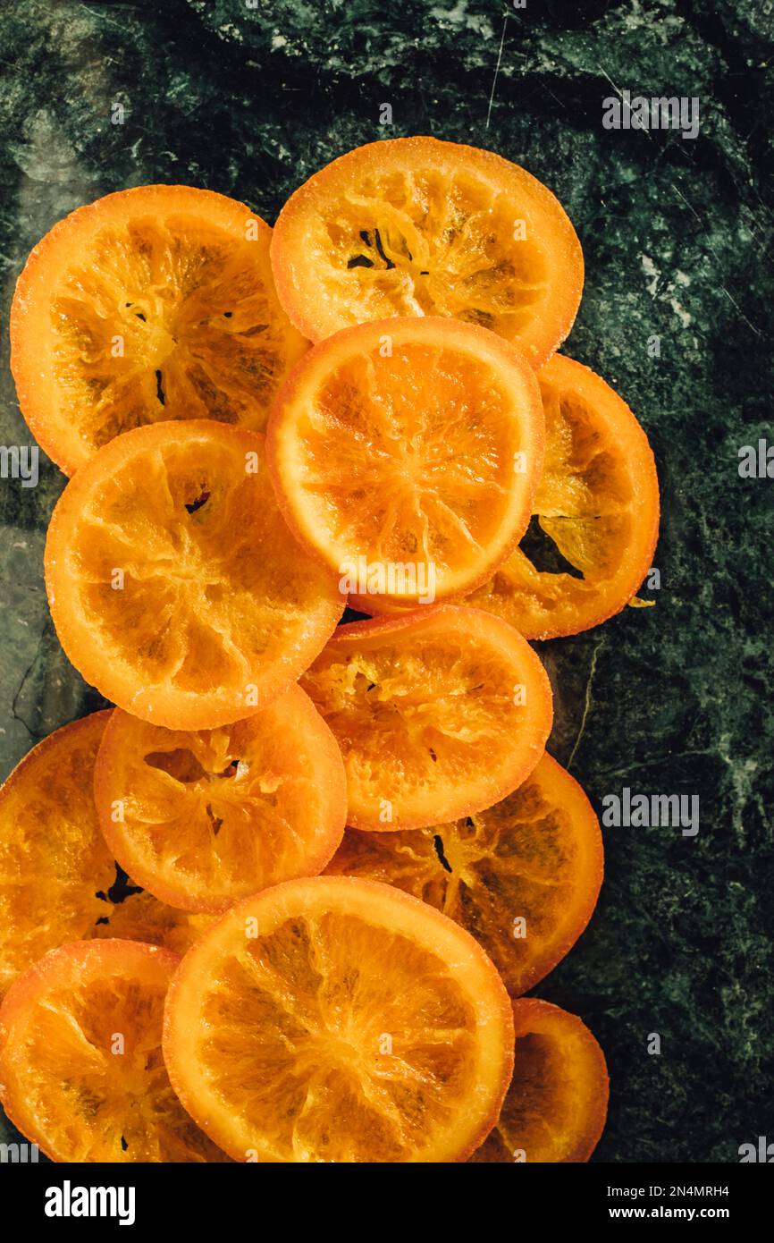 Candied orange slices laid out on green marble Stock Photo - Alamy