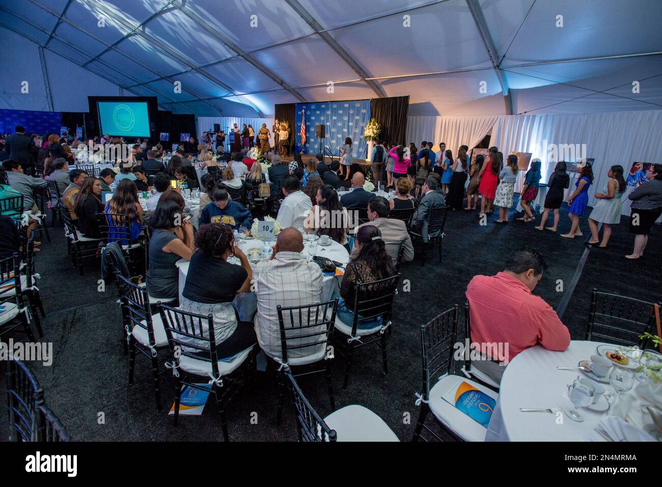 Students and family watch graduates cross the stage to receive their ...