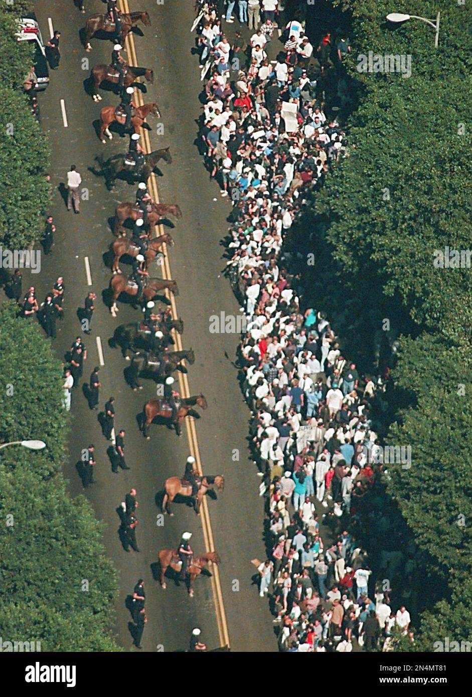 FILE - In this Oct. 3, 1995 file photo, police line up opposite crowds ...