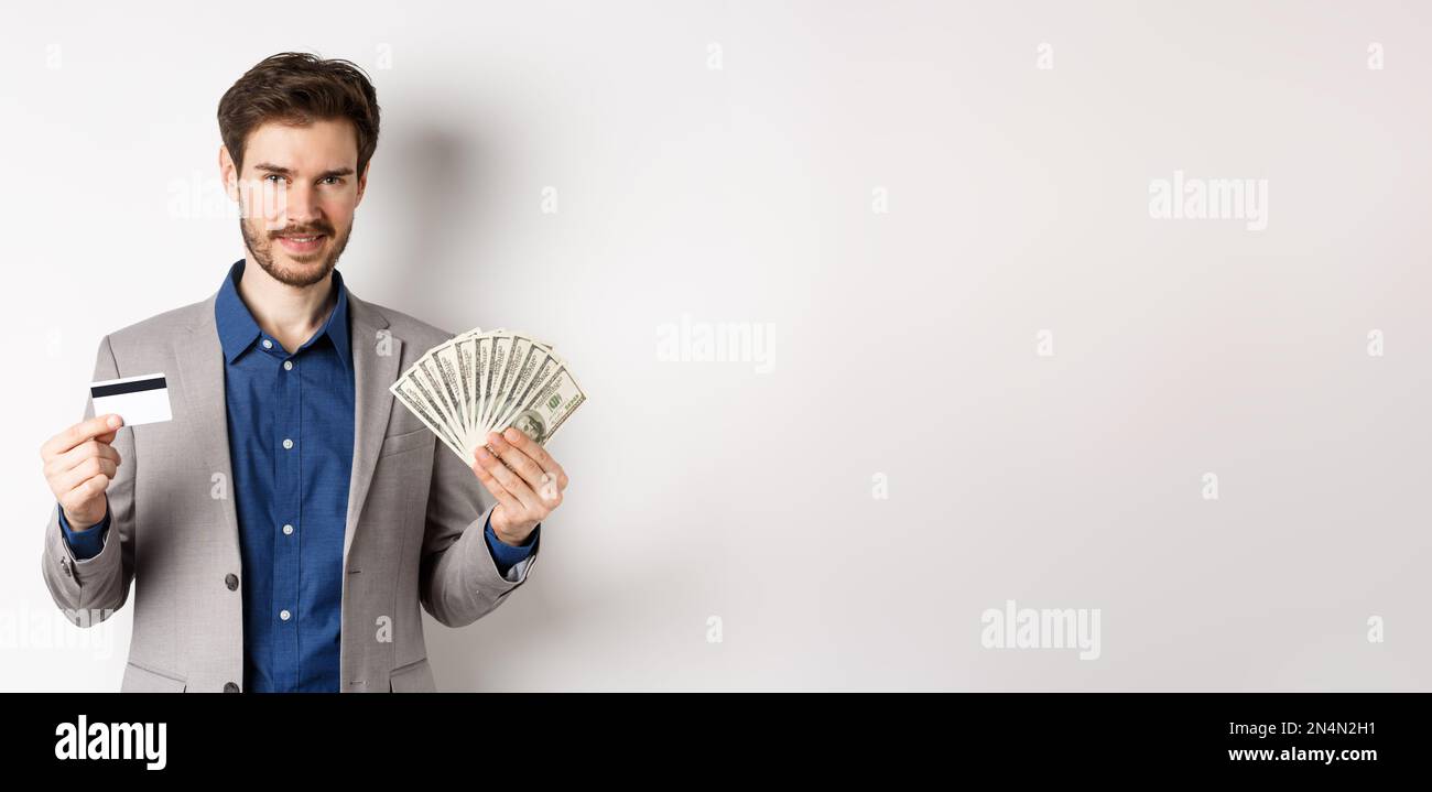 Rich smiling man in suit showing money and plastic credit card ...