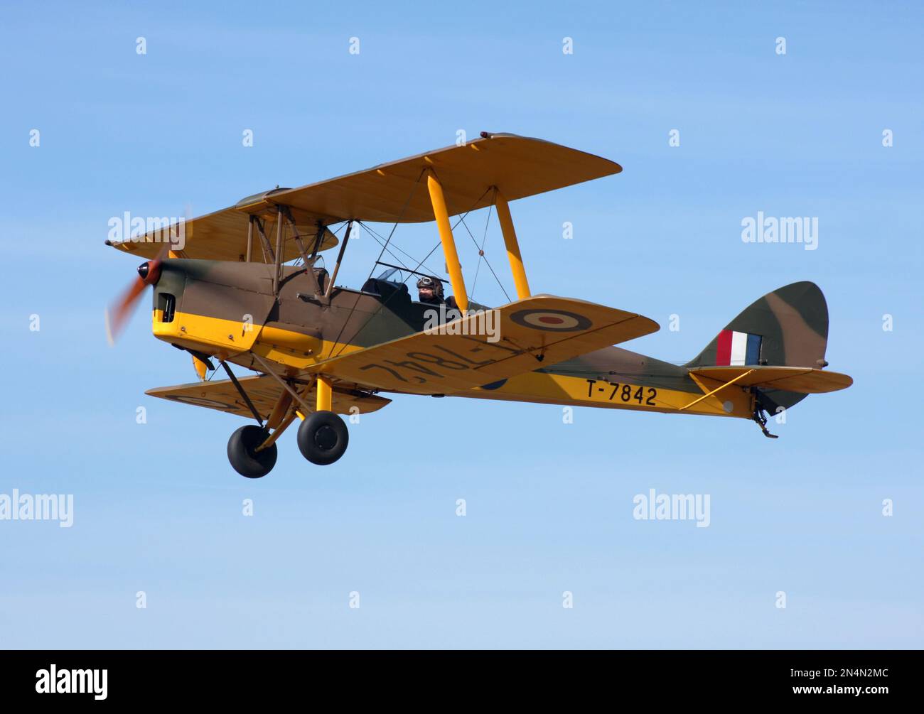 A De Havilland DH-82 Tiger Moth departs Headcorn airfield Kent England ...