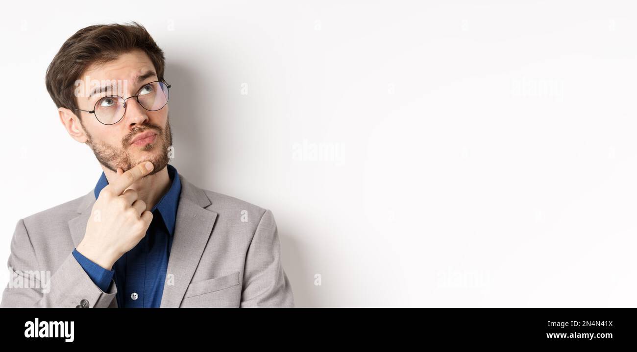 Thoughtful businessman with beard and glasses making decision, looking ...
