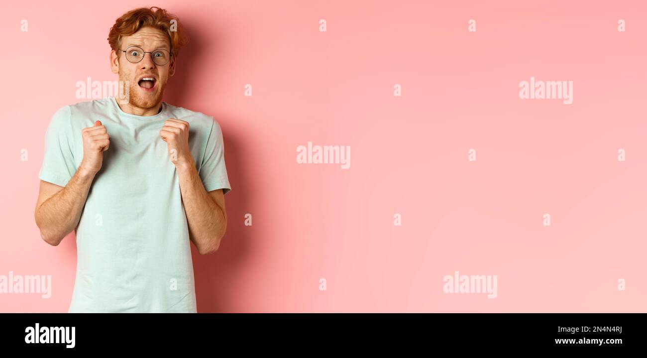 Portrait of scared redhead guy in glasses staring startled at camera ...