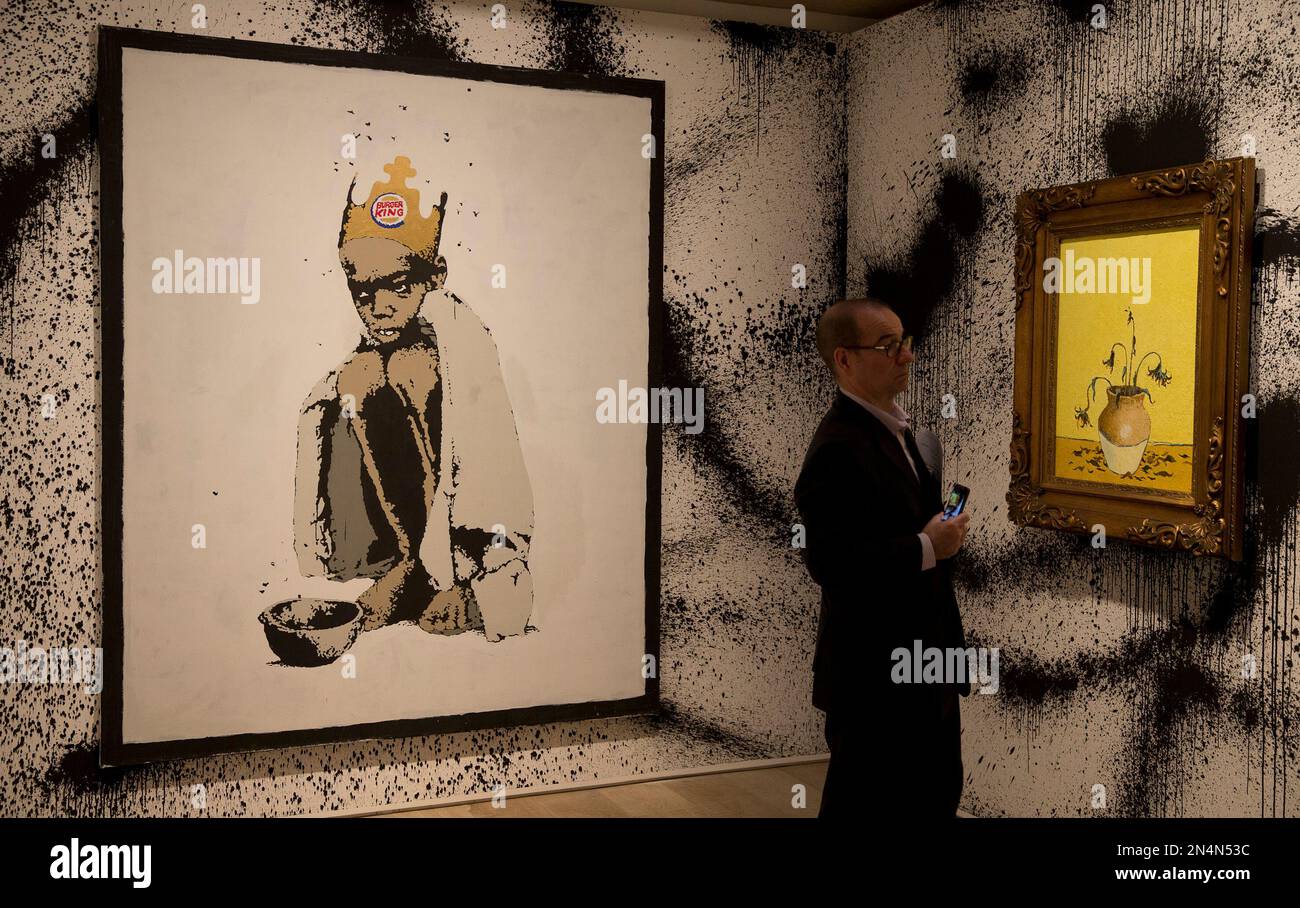 A member of the media looks at artwork by British artist Banksy during ...