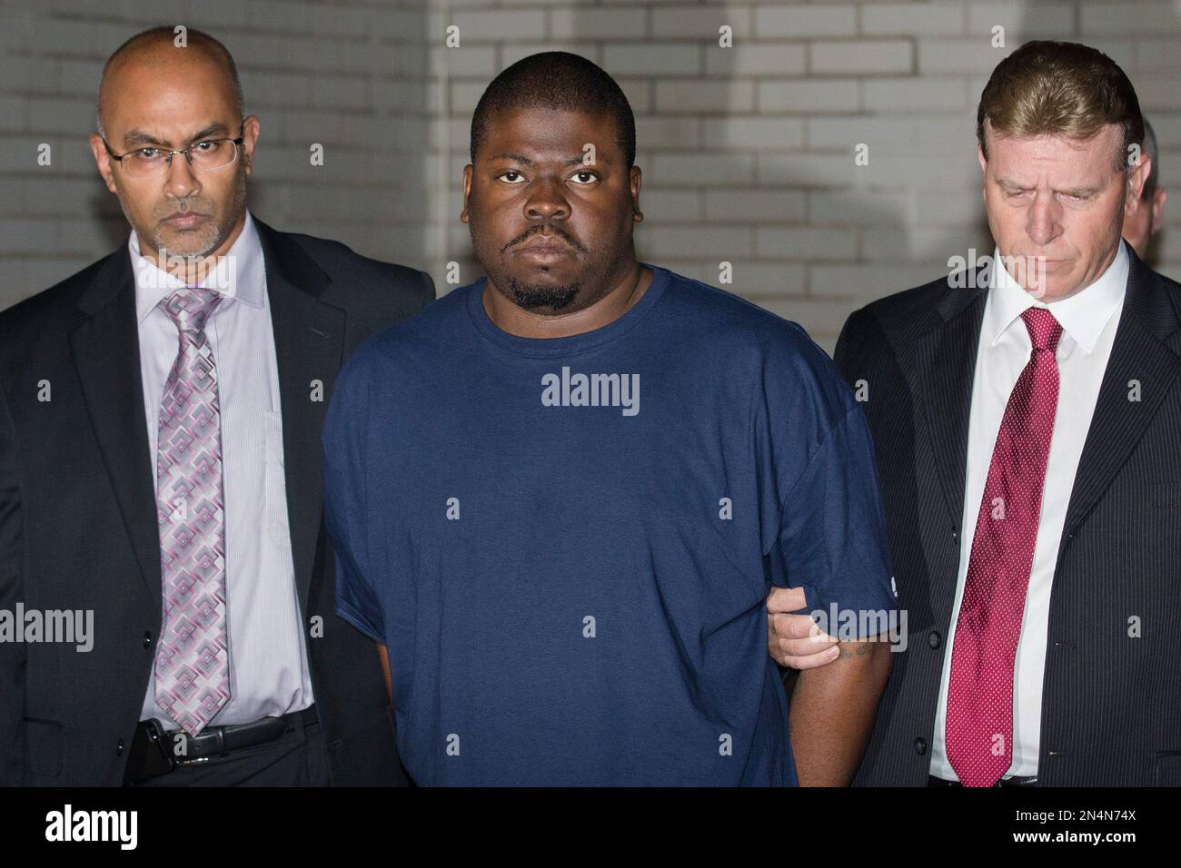 Daniel St. Hubert, center, is led from the 90th precinct by police ...