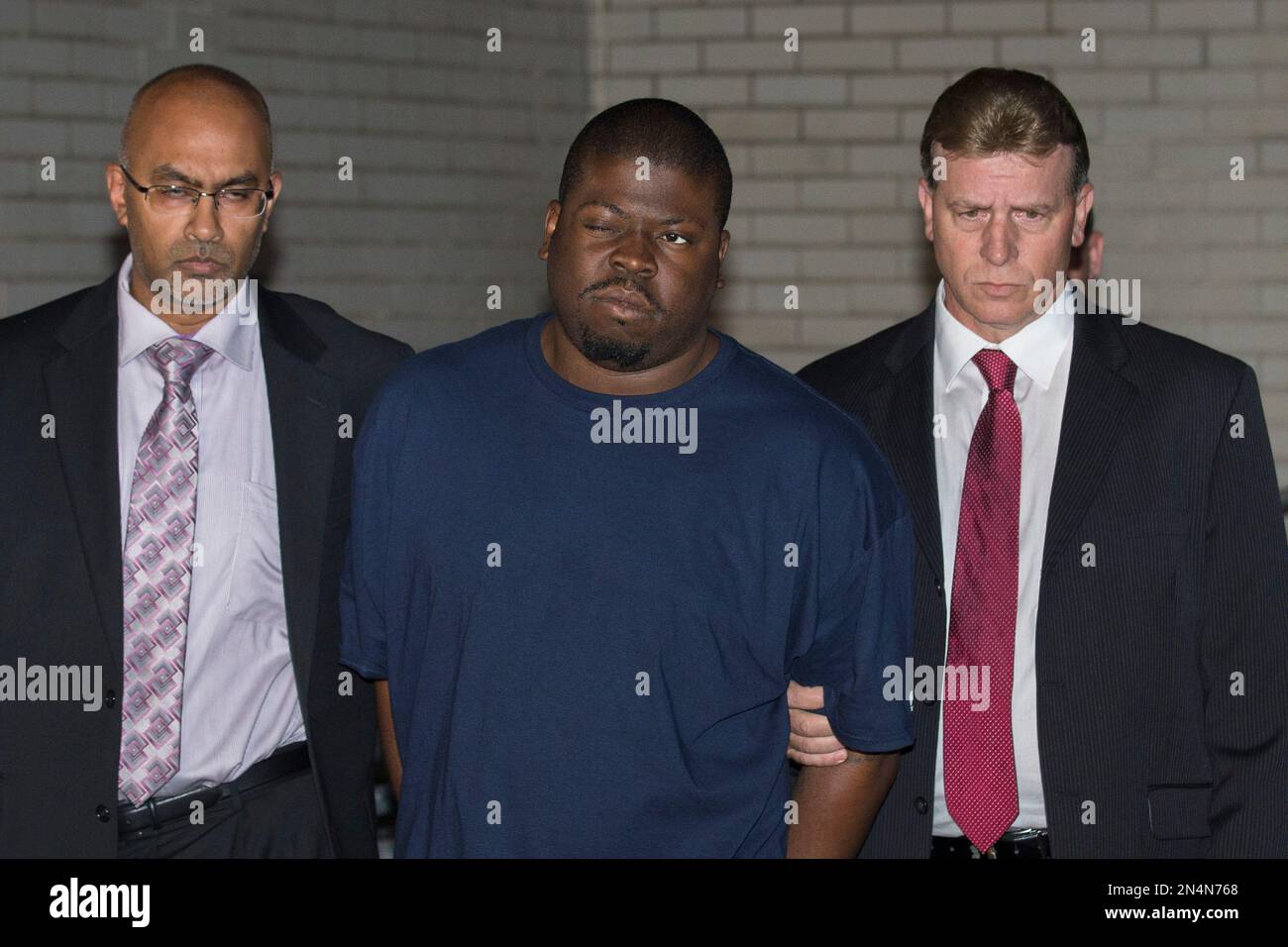 Daniel St. Hubert winks as he is led from the 90th precinct by police ...