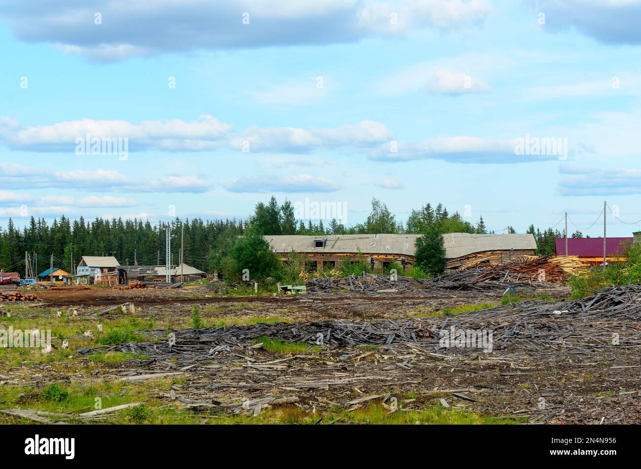 An old building with a sagging roof near an abandoned sawmill field in ...