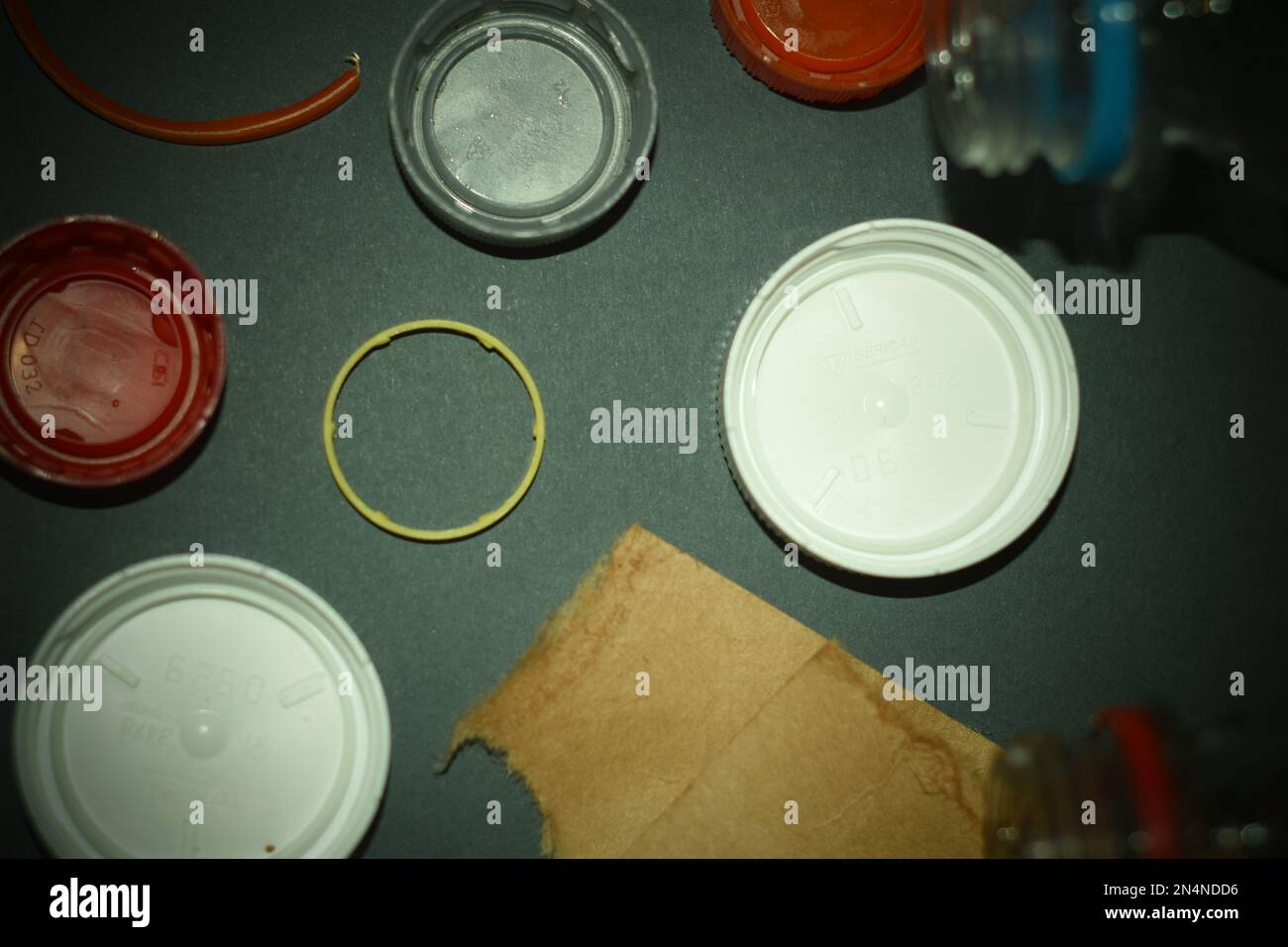 Plastic bottle caps, bottles and cardboard on a gray background ...