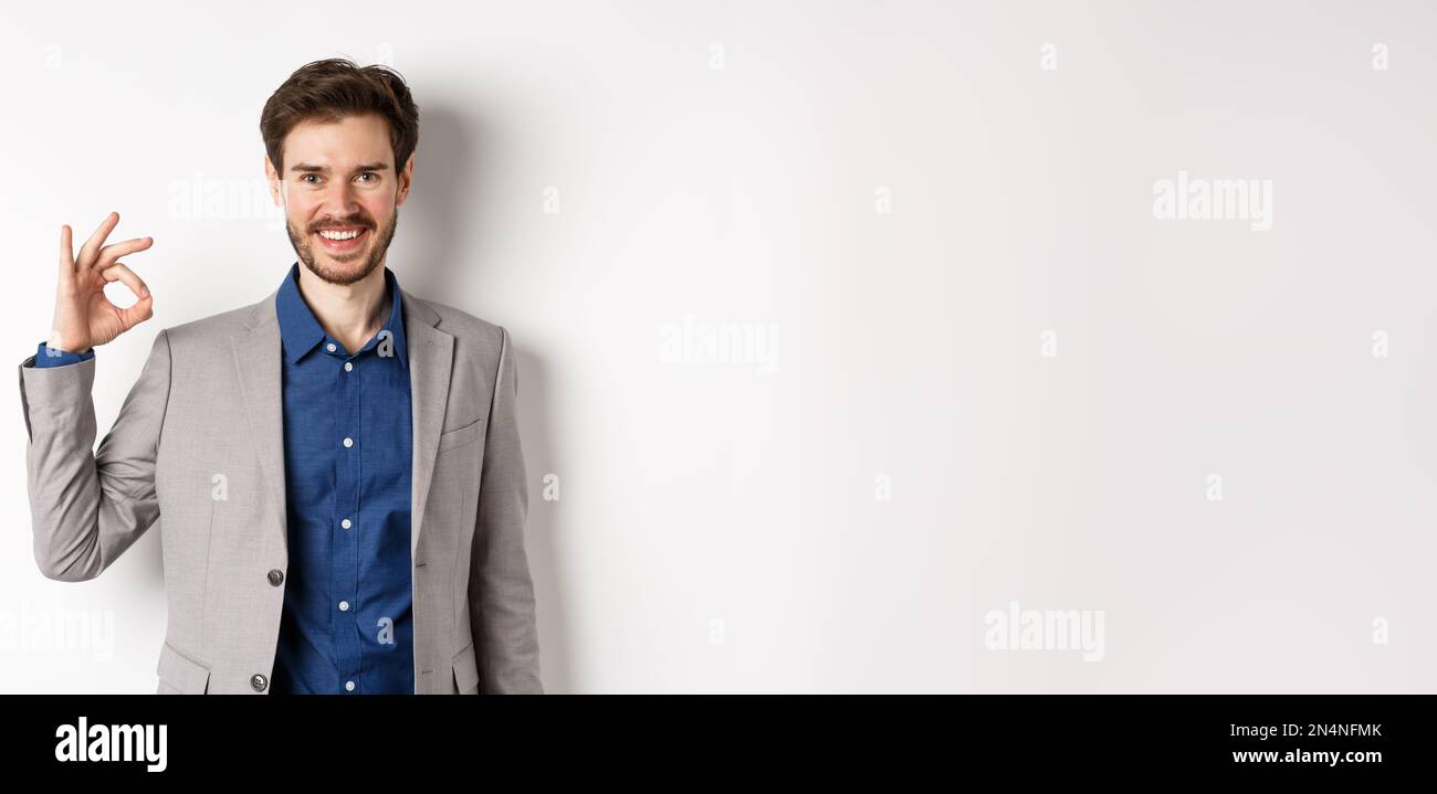 Smiling successful businessman in suit showing okay sign, looking ...