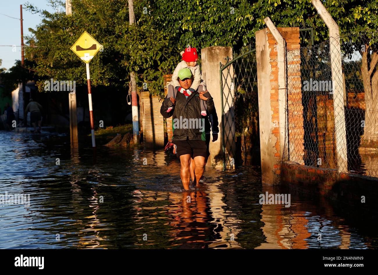 Oscar Caballero carries his daughter Nadia to school as he wades ...