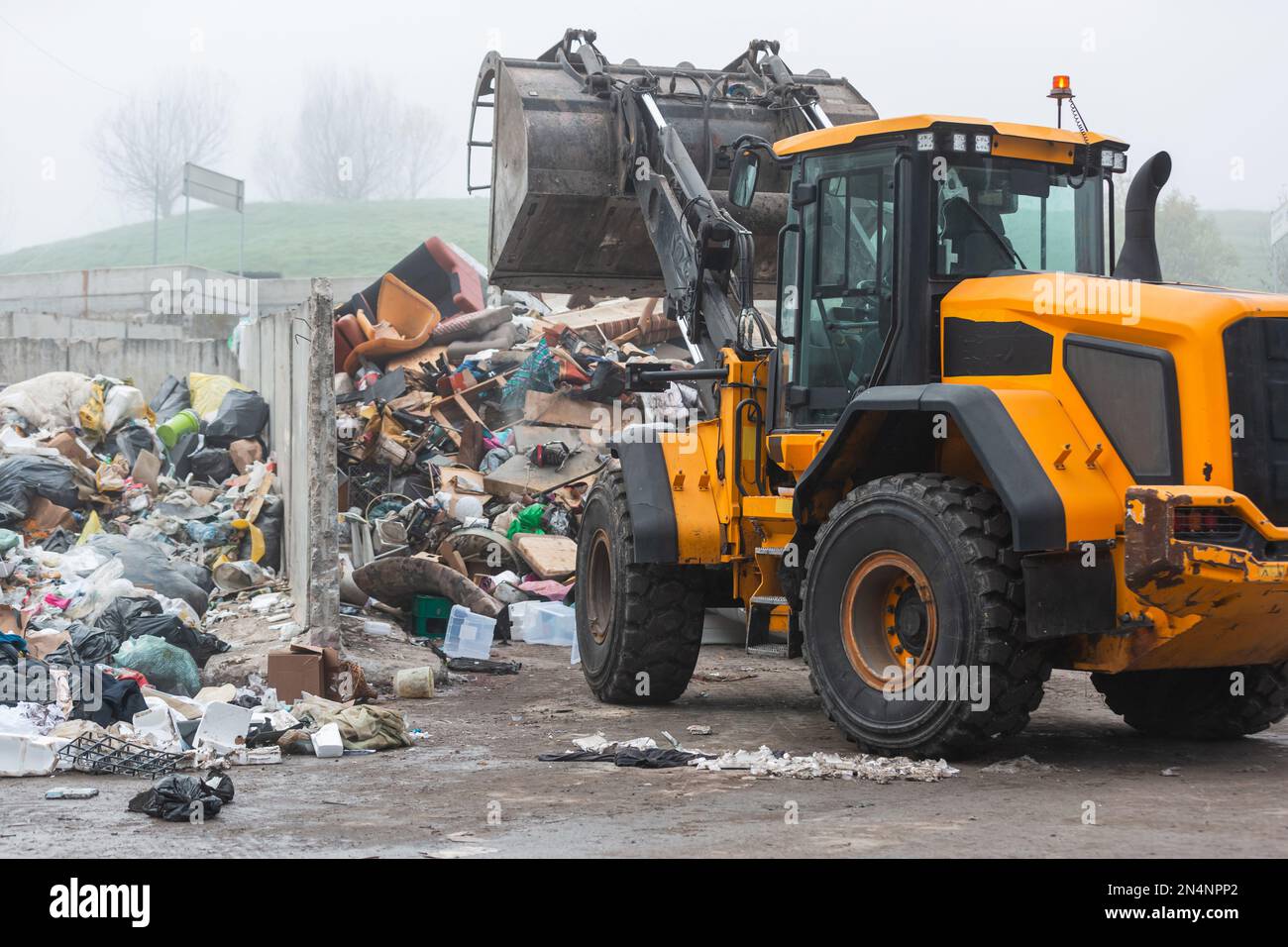 Front loader with scrap handling grapple bucket moving forward and ...