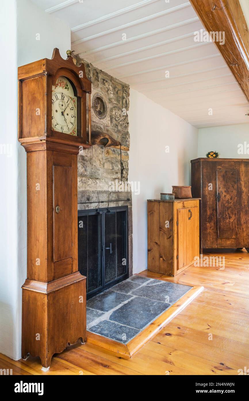 Living room with circa 1825 Grandfather clock, stone chimney fireplace ...