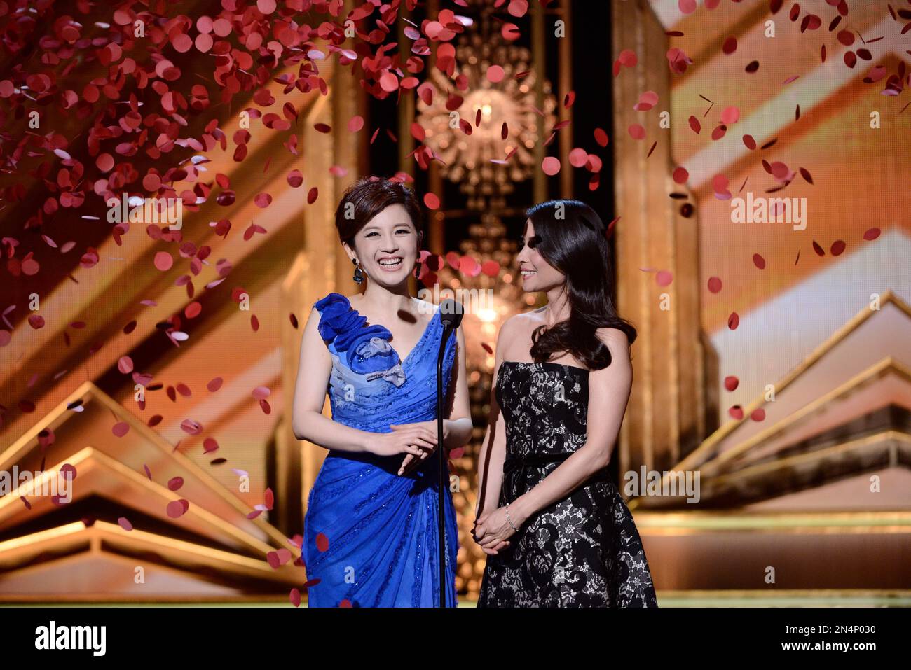 Co-hosts Olivia, Xu, left, and Lucy Liu speak on stage at the Huading ...