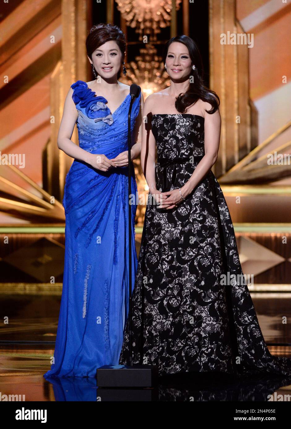 Co-hosts Olivia, Xu, left, and Lucy Liu speak on stage at the Huading ...