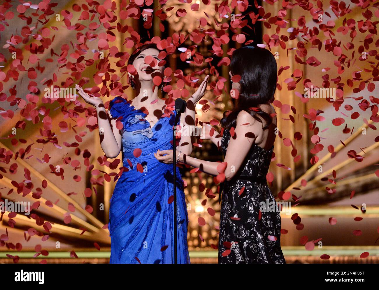Co-hosts Olivia, Xu, left, and Lucy Liu speak on stage at the Huading ...