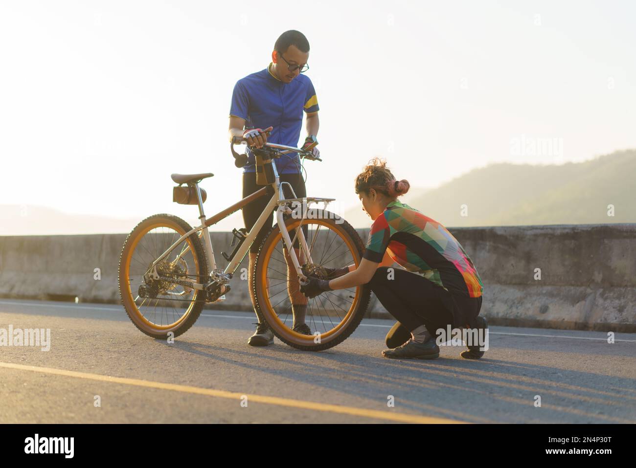 Asian cyclist couple assembles bikes for a morning bike ride by the ...