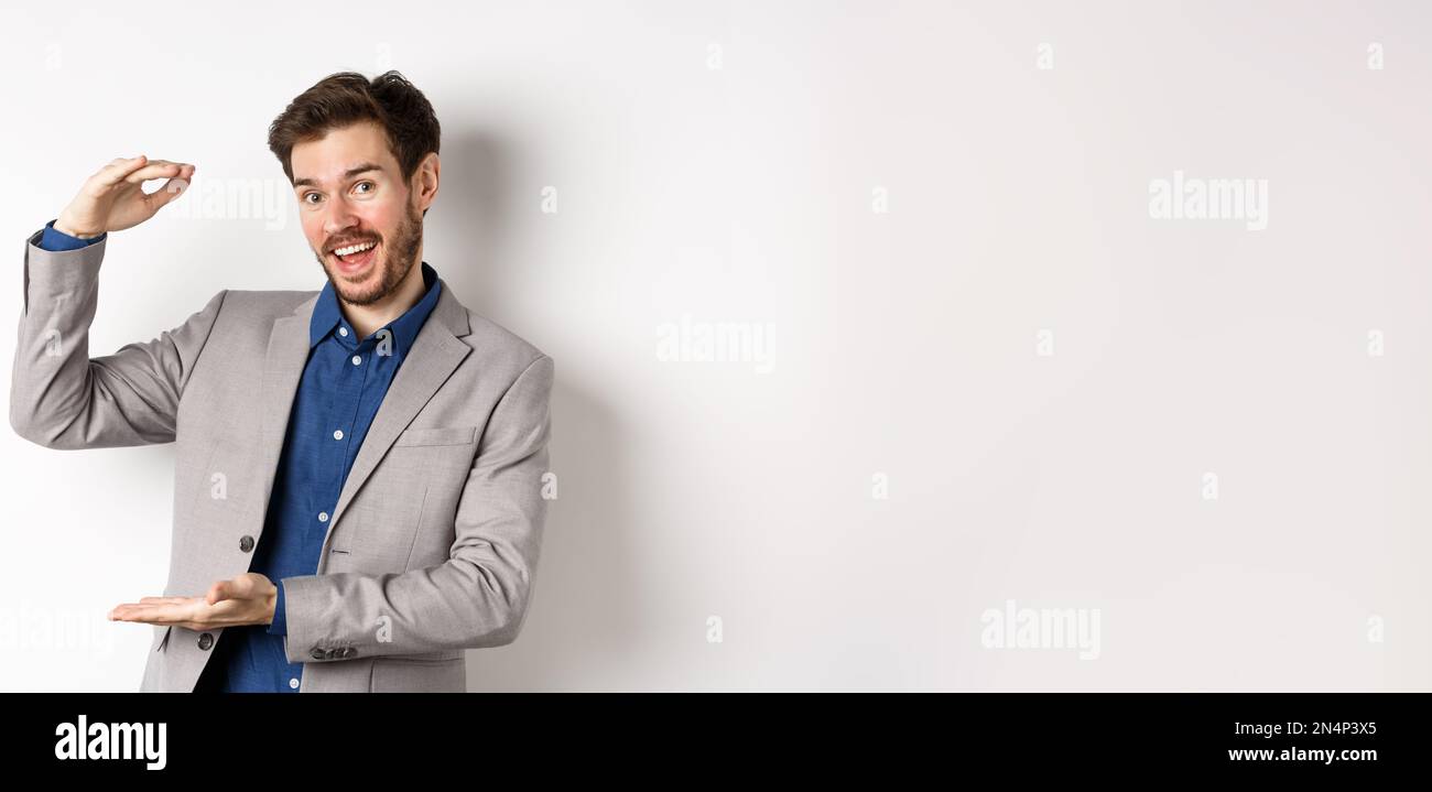 Handsome salesman in suit showing big size, large income, smiling at ...