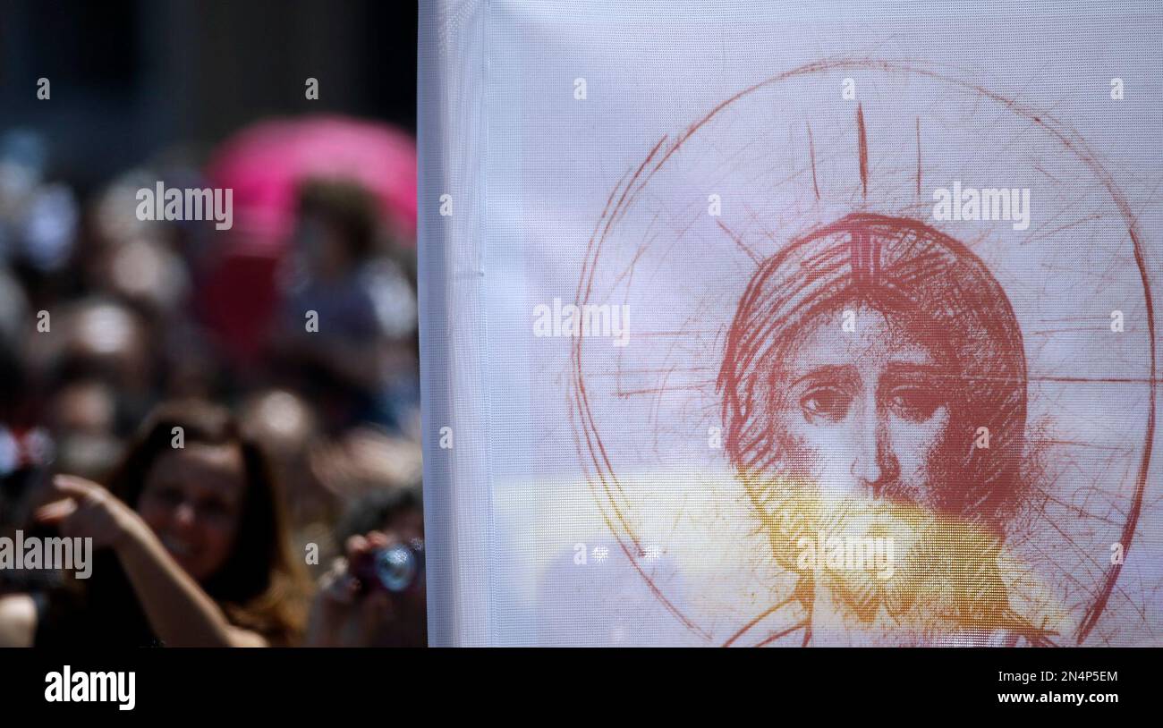 Faithful hold a banner showing the image of Jesus Christ during Pope ...