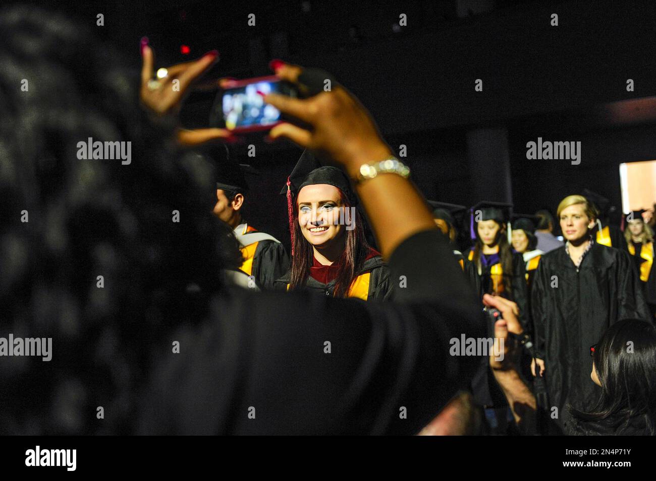 A procession of graduating students make their way into the ceremony at ...