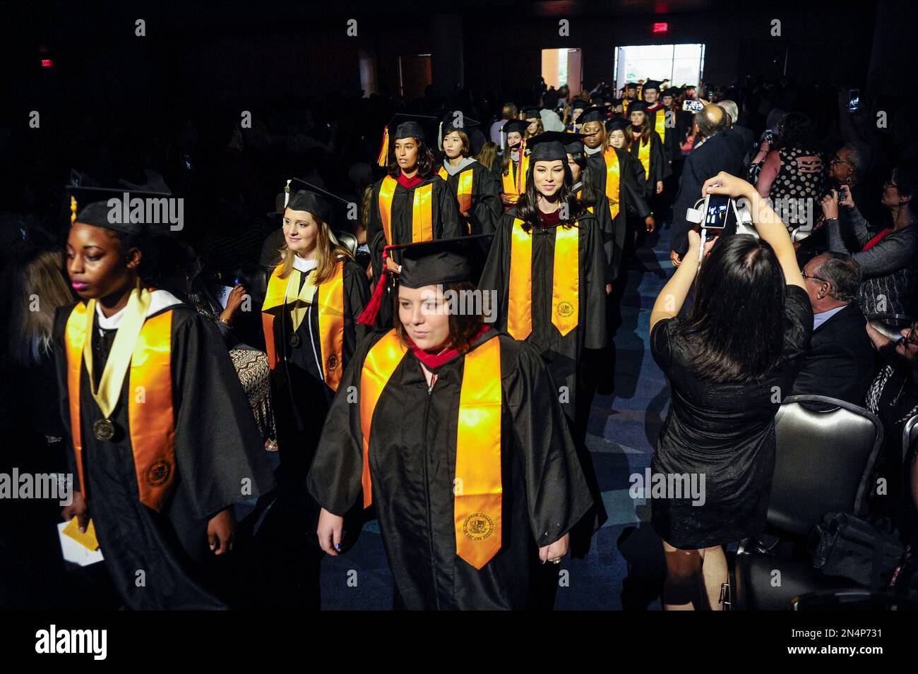 A procession of graduating students make their way into the ceremony at ...