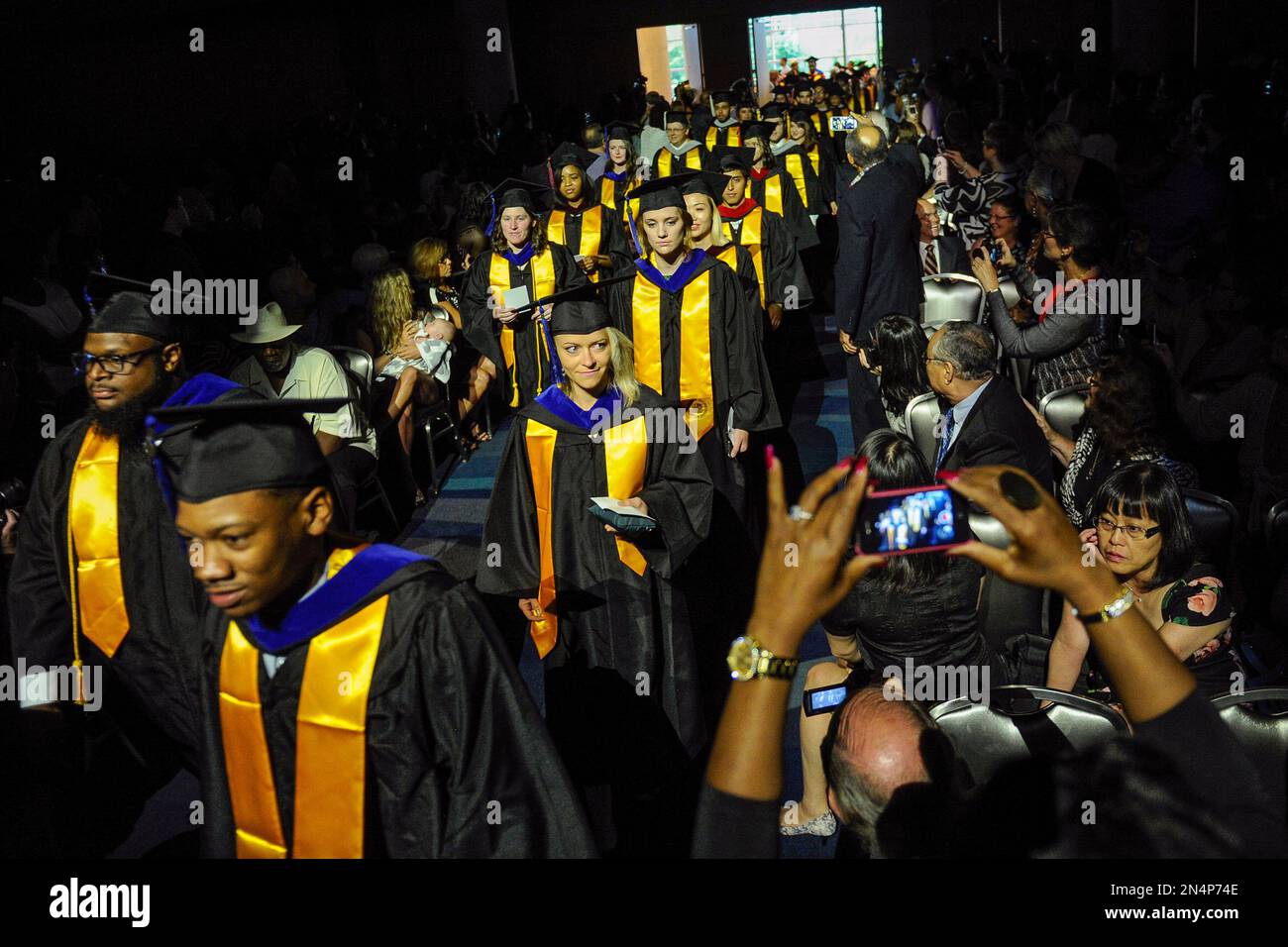 A procession of graduating students make their way into the ceremony at ...