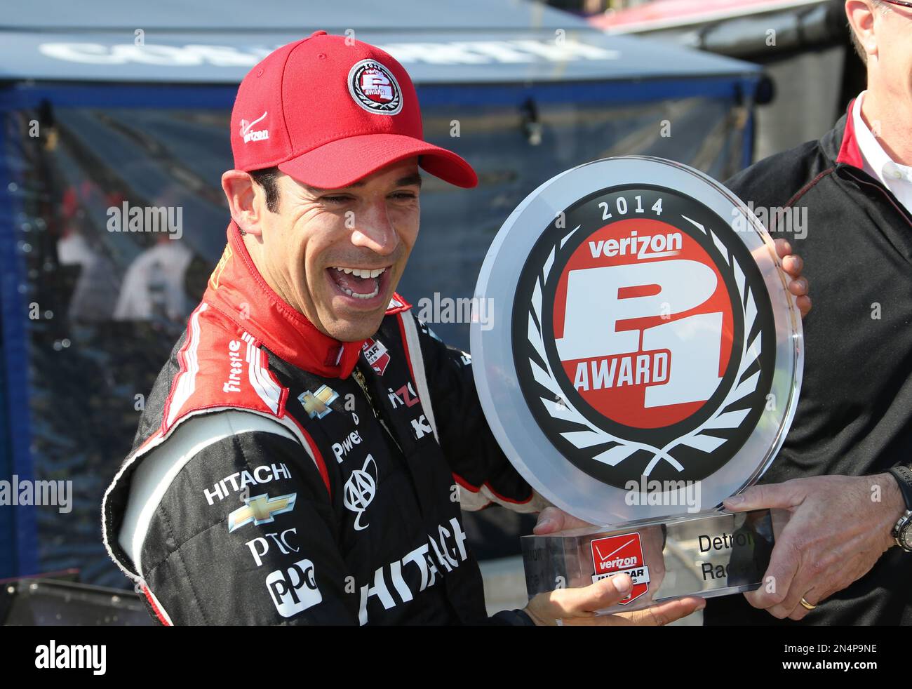 Driver Helio Castroneves reacts as he poses with the pole position ...