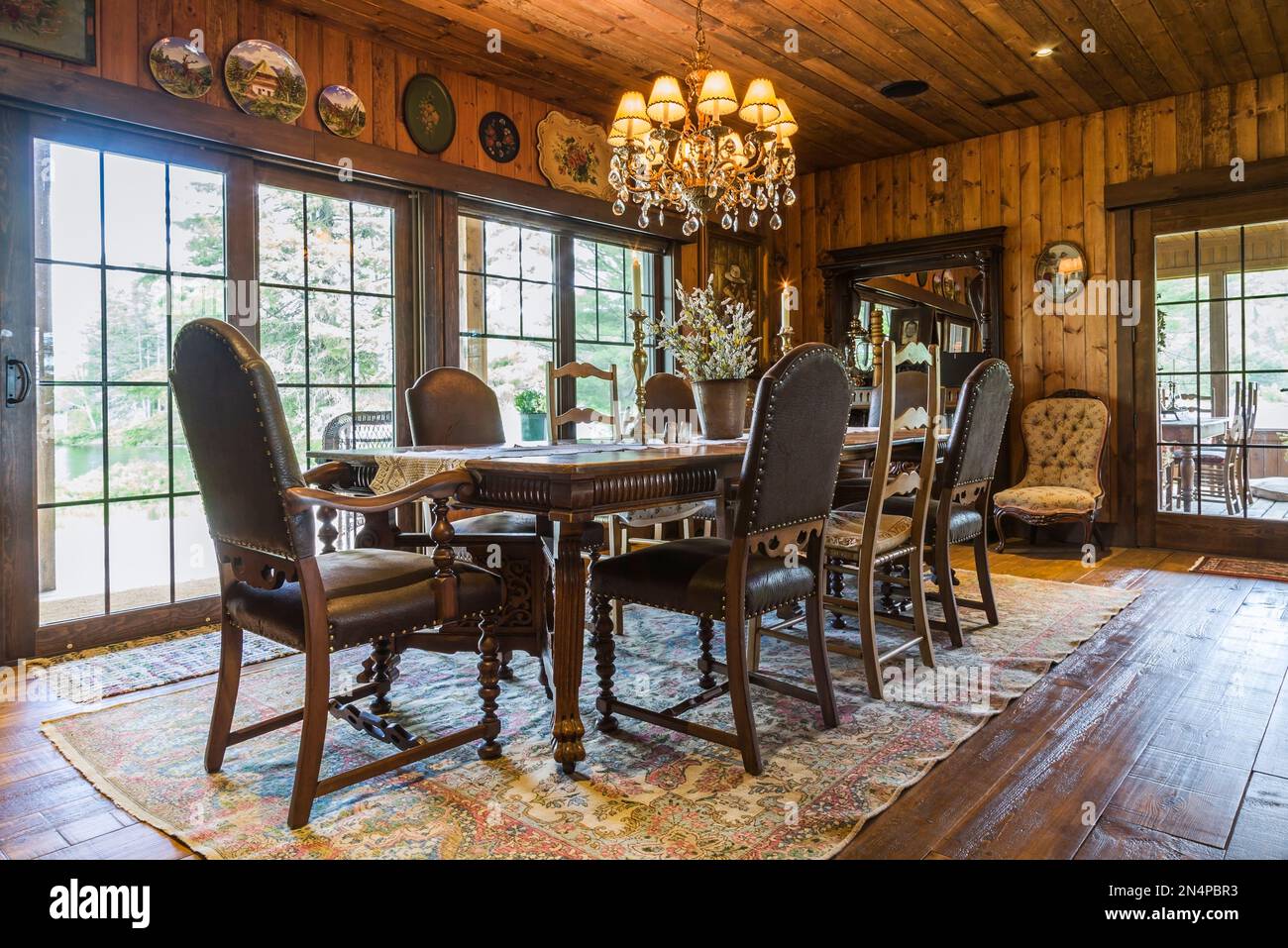 Dining room with antique wooden table and high back brown leather ...
