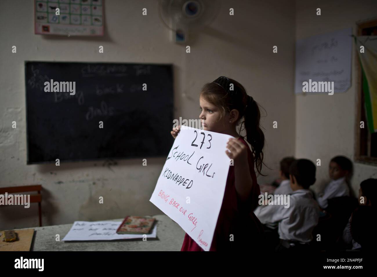 A Pakistani schoolgirl holds a hand-written sign during a special class ...