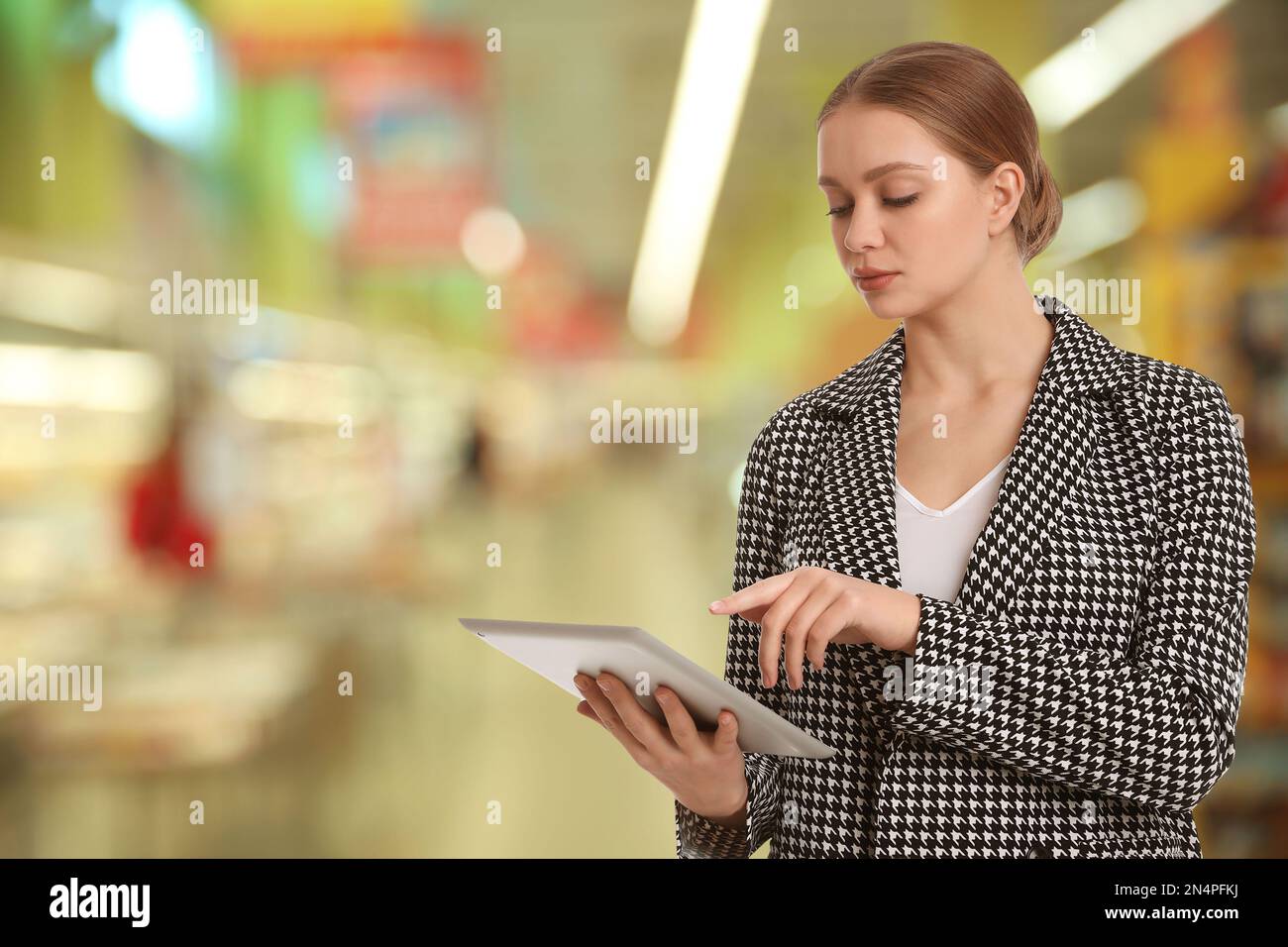 Inspector with tablet in shopping mall, space for text. Quality control ...