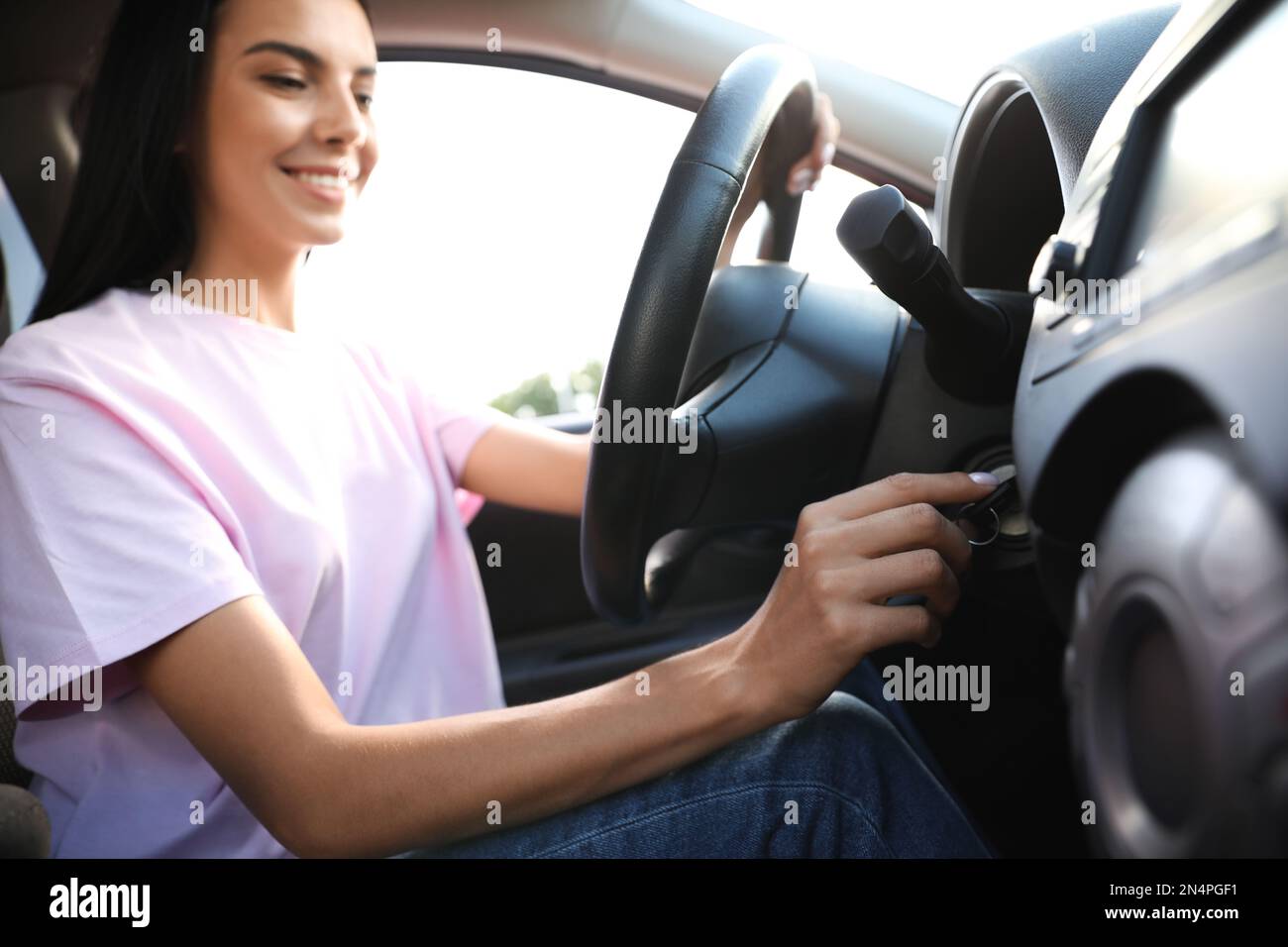 Young woman starting engine of car. Driving school Stock Photo - Alamy