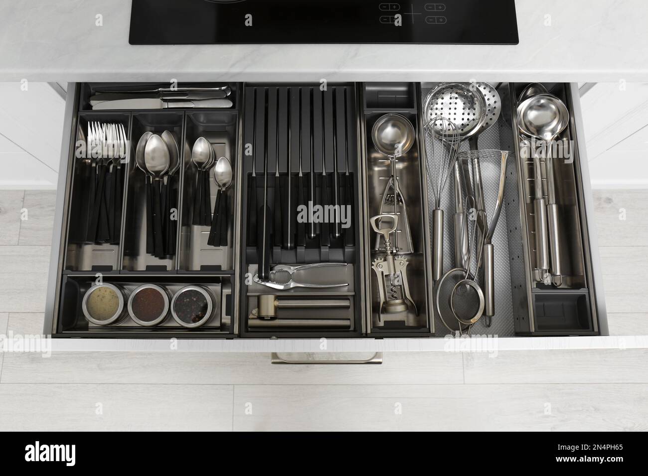 Open drawer with stainless steel utensil set. Order in kitchen Stock ...