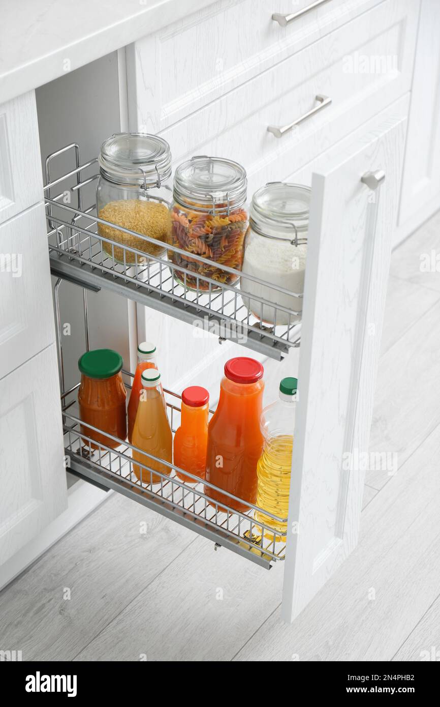 Open drawer with jars of food and juice bottles in kitchen Stock Photo ...