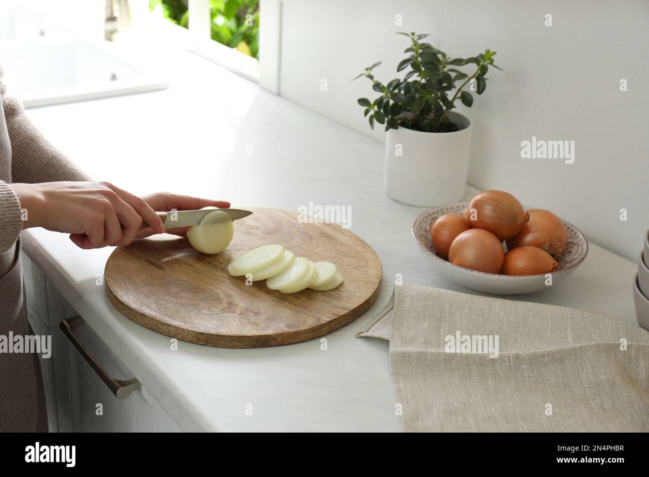 Woman cutting white onion into rings at countertop, closeup Stock Photo ...