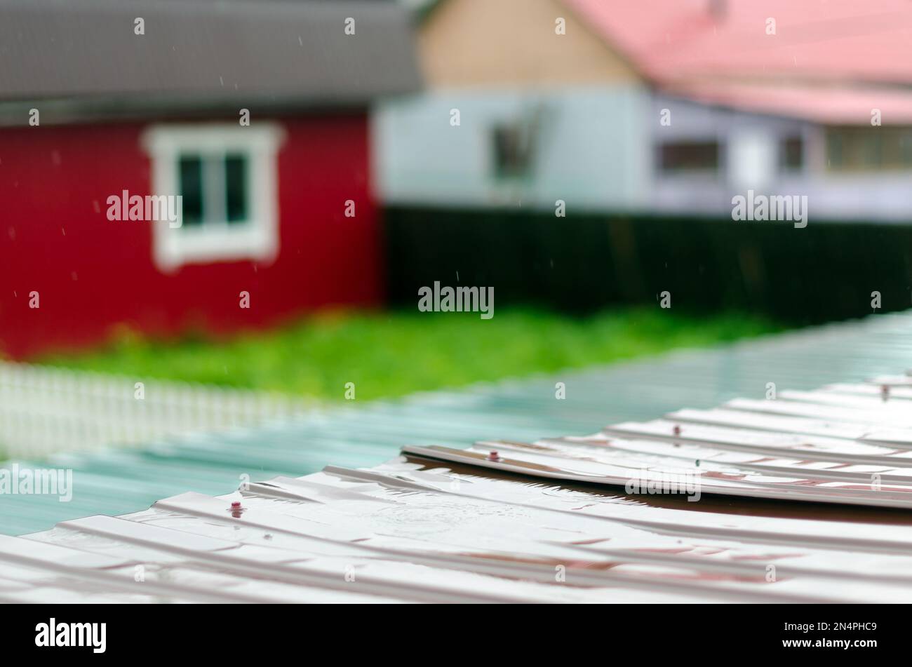 A puddle of raindrops is collected in the hollow of the roof of a ...