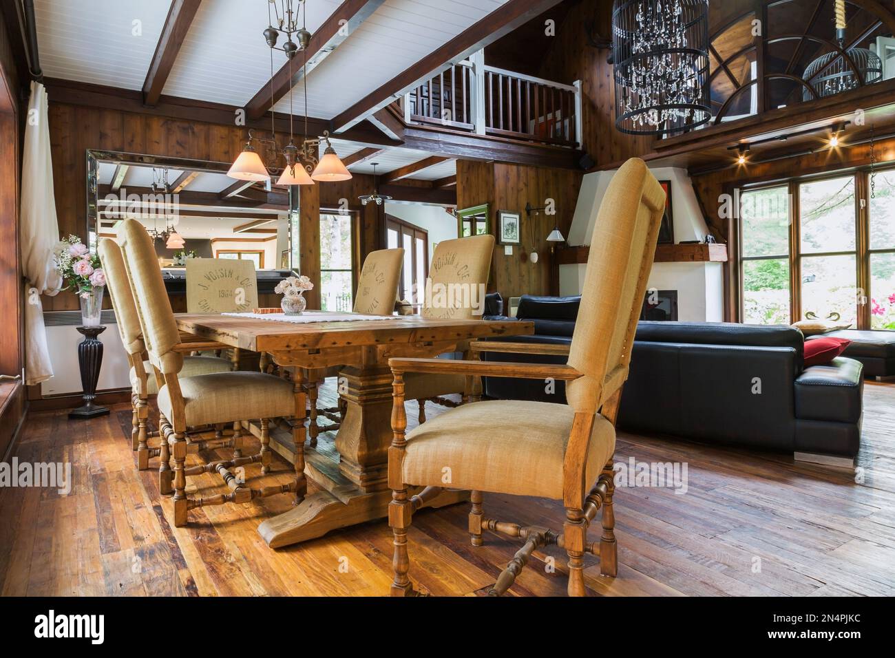 Rustic wooden table with beige linen cloth upholstered chairs in dining ...