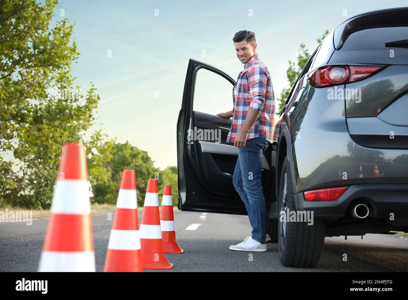 Man near car and traffic cones outdoors. Driving school exam Stock ...