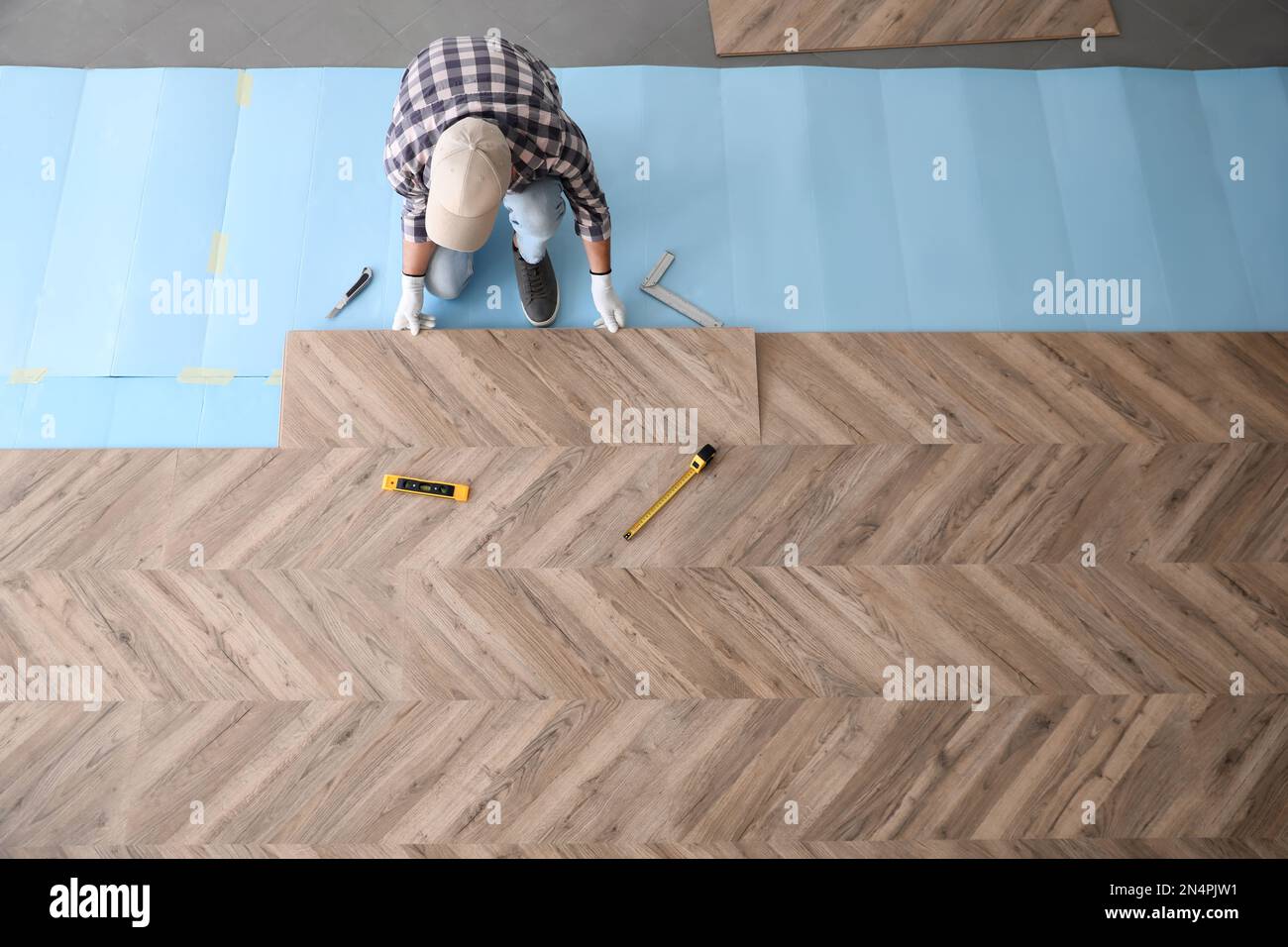 Worker installing laminated wooden floor indoors, above view Stock ...