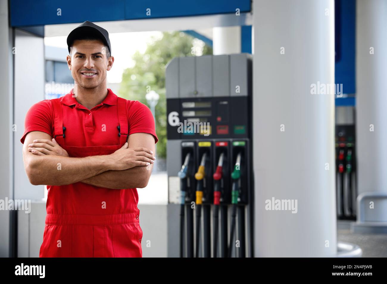 Worker in uniform at modern gas station Stock Photo - Alamy