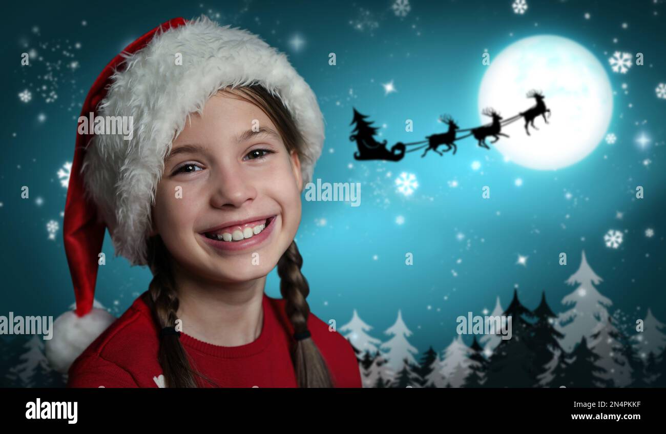 Cute little child and Santa Claus flying in his sleigh against moon sky ...
